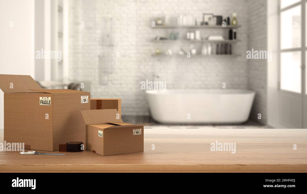 Wooden table, desk or shelf with stack of cardboard boxes over blurred ...