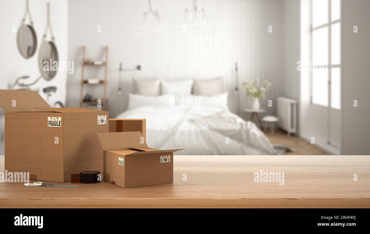 Wooden table, desk or shelf with stack of cardboard boxes over blurred ...