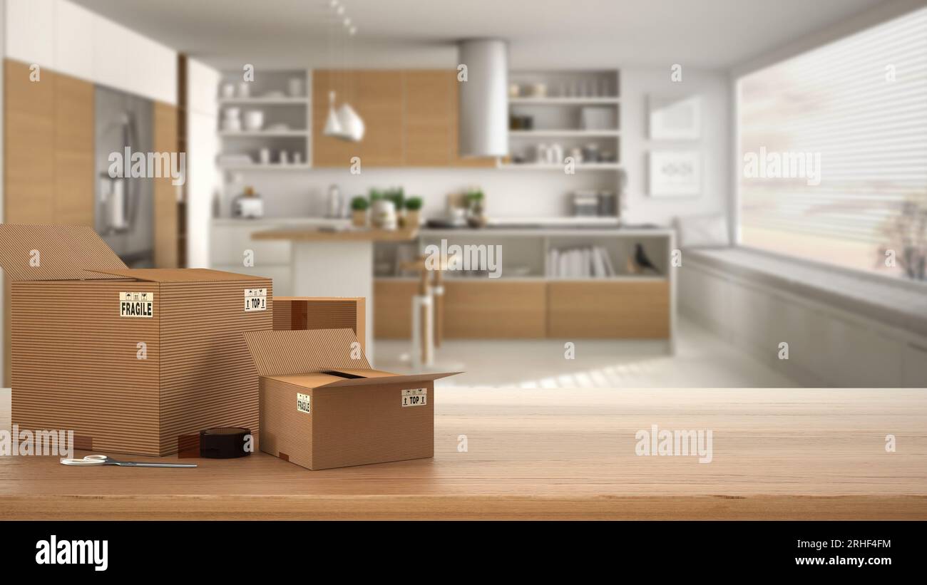 Wooden table, desk or shelf with stack of cardboard boxes over blurred ...