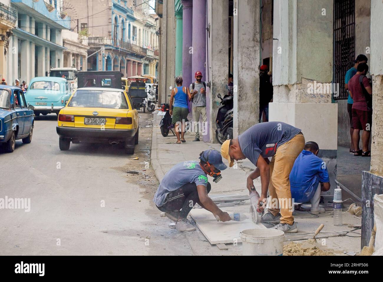 Havana, Cuba, Three people work repairing or changing a part of the ...