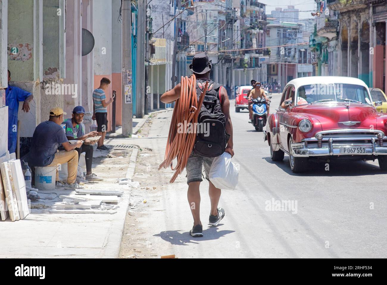 Havana, Cuba, A Cuban man walks with a roll of plastic tube in his ...
