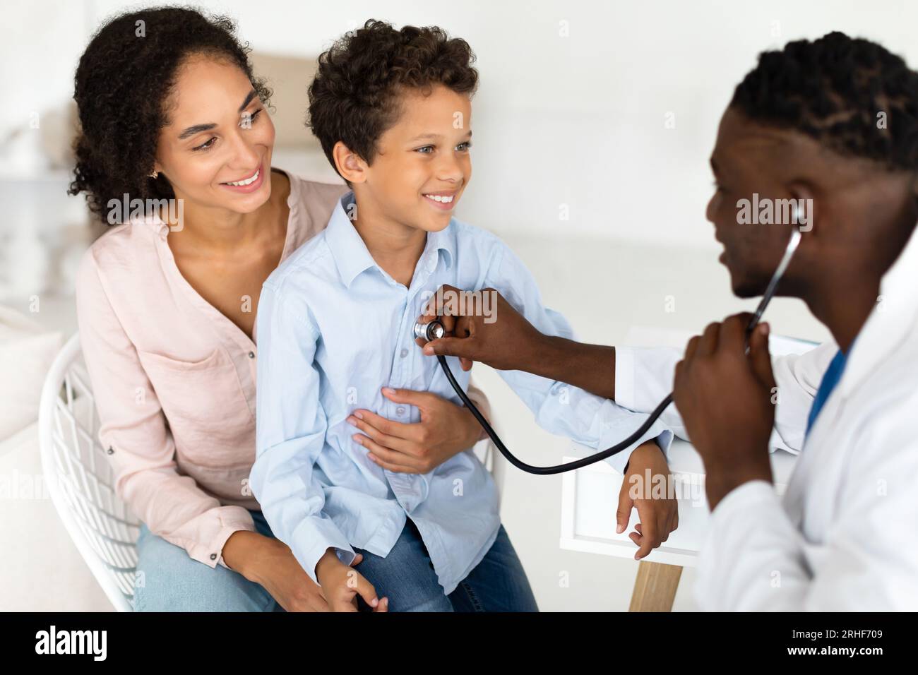 Mother And Son Visiting Family Doctor During Appointment In Clinic ...
