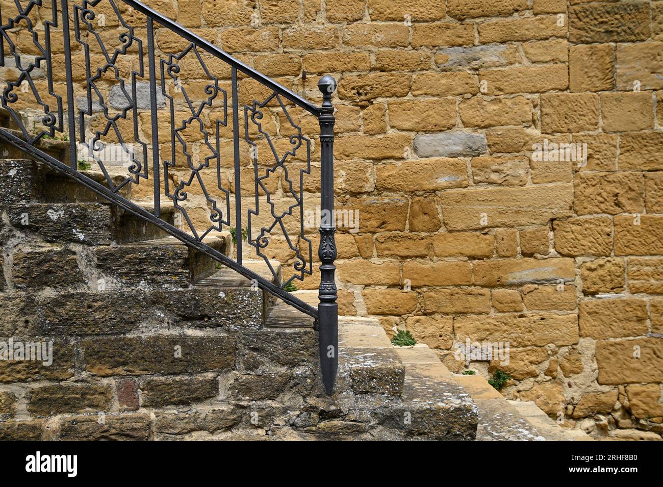 Antique stairway with a wrought iron railing against a vintage brick ...