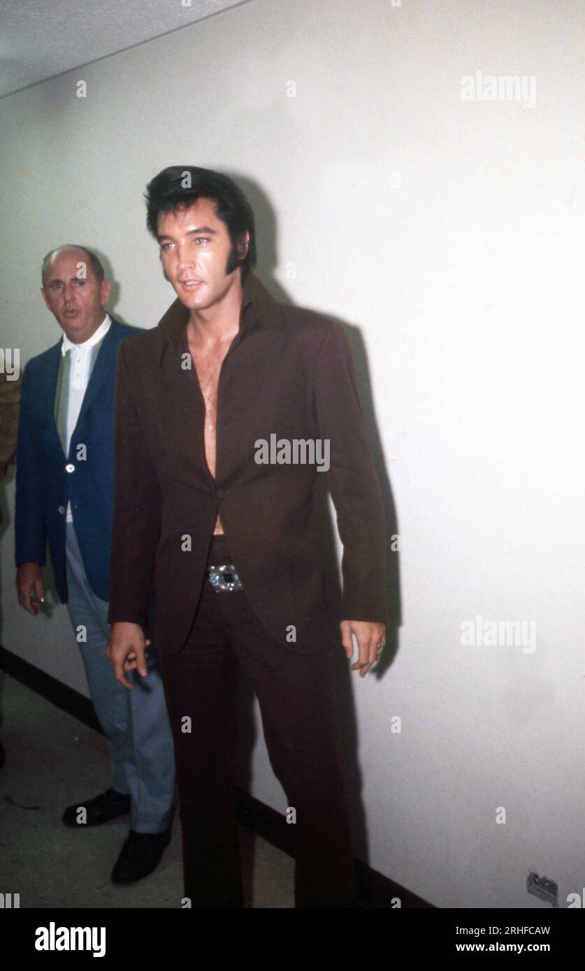 Elvis Presley wearing a black jacket, in front of manager Col. Tom ...