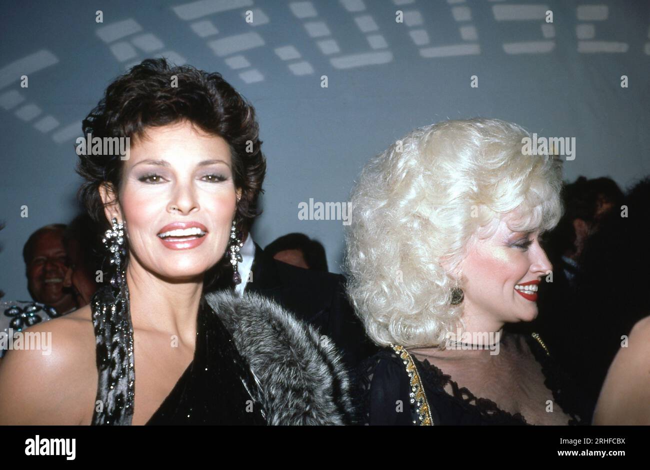 Raquel Welch is smiling with Dolly Parton, at a charity event for ...