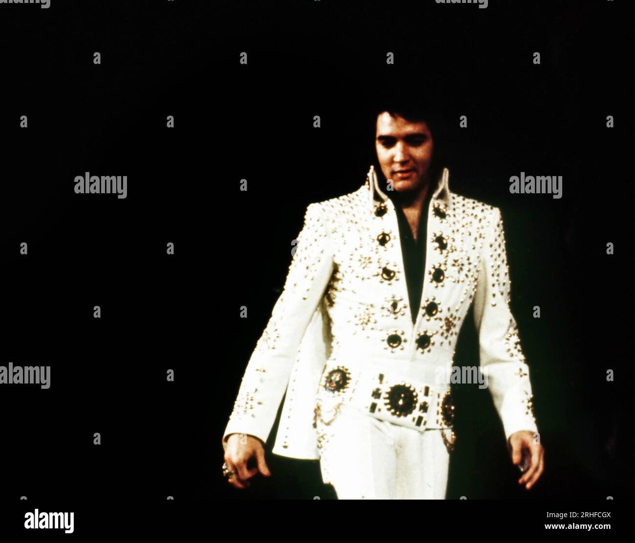 Elvis Presley wearing one of his iconic white embellished jumpsuits ...