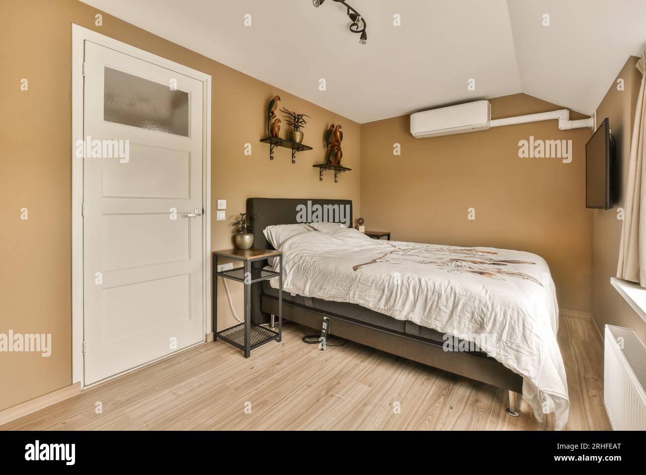 a bedroom with an air condition system on the wall, and a bed in the ...