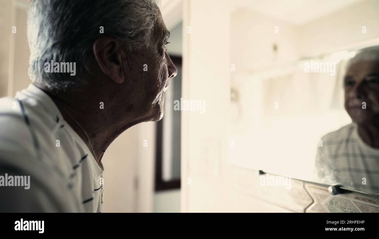 Senior man looking at bathroom mirror reflection. Elderly gray-hair ...