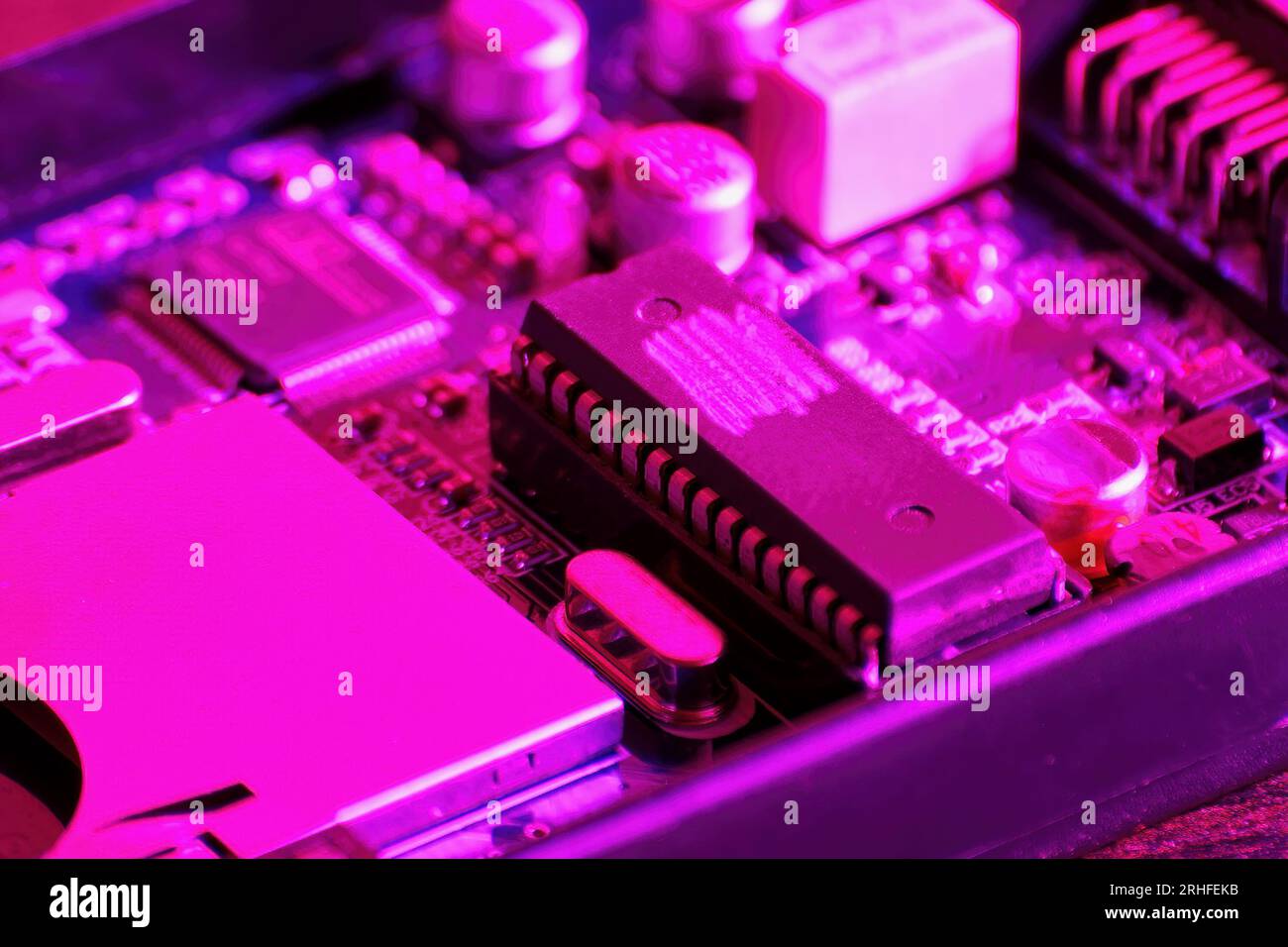 Closeup view of complex modern pcb with processor in the pink neon ...