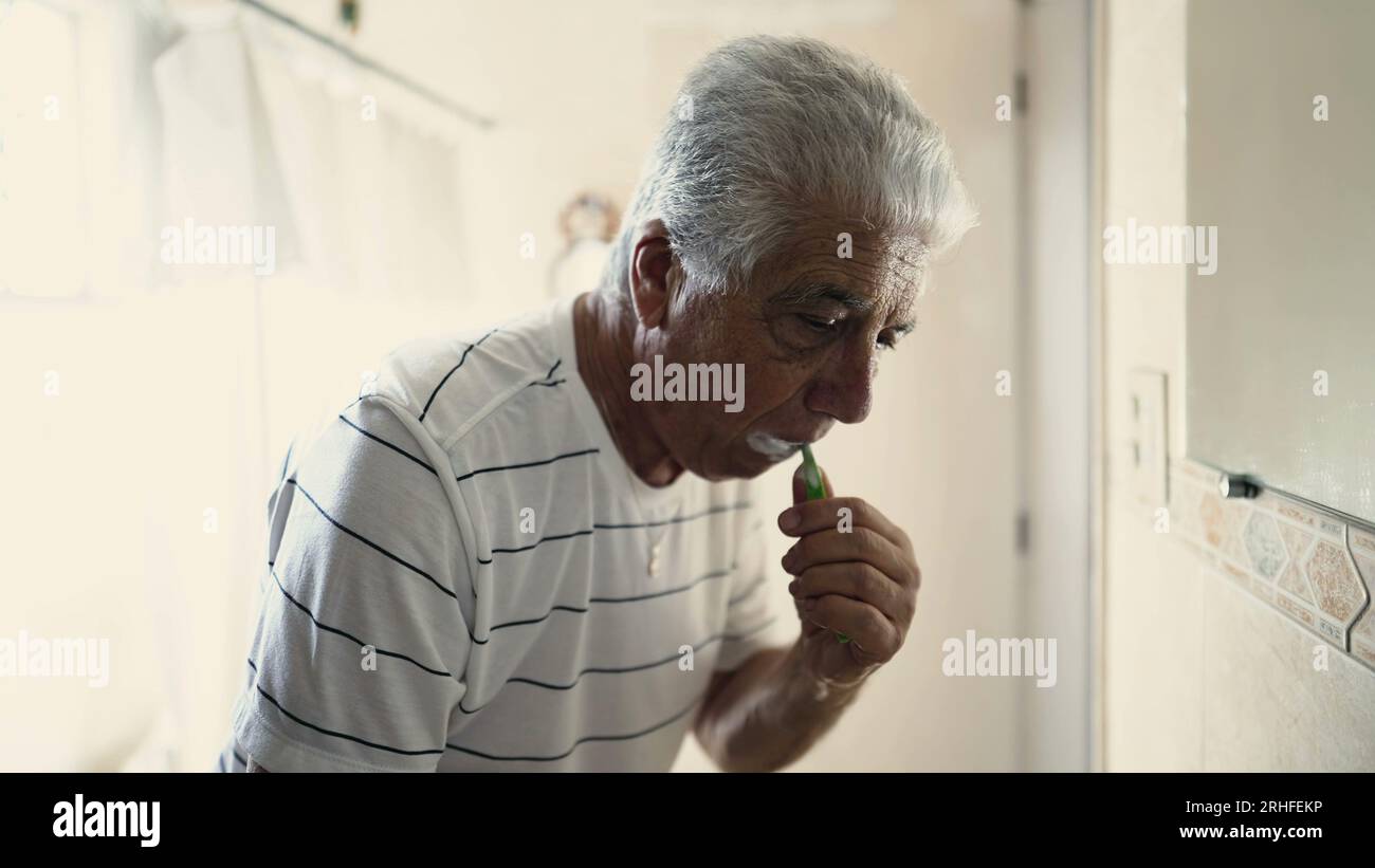 Senior morning routine brushing in mirror while staring at his own ...