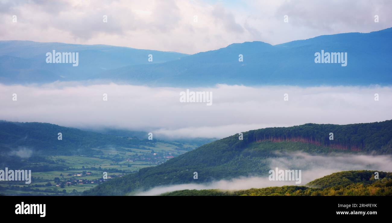 beautiful dawn in mountains with fog in the valley. forested hills ...