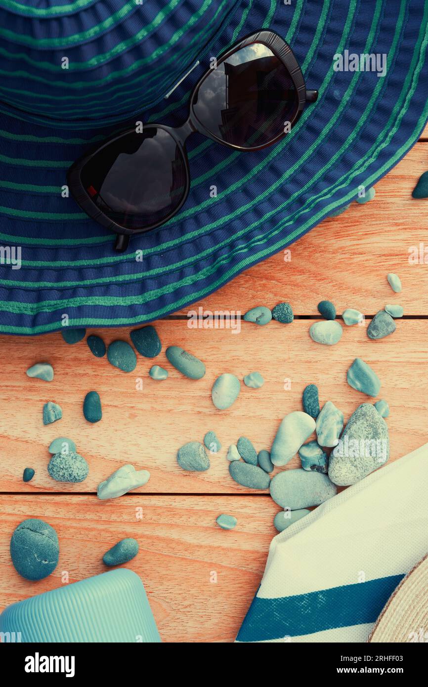 Big blue sun hat, bottle with cream, beach bag and pebbles on the ...