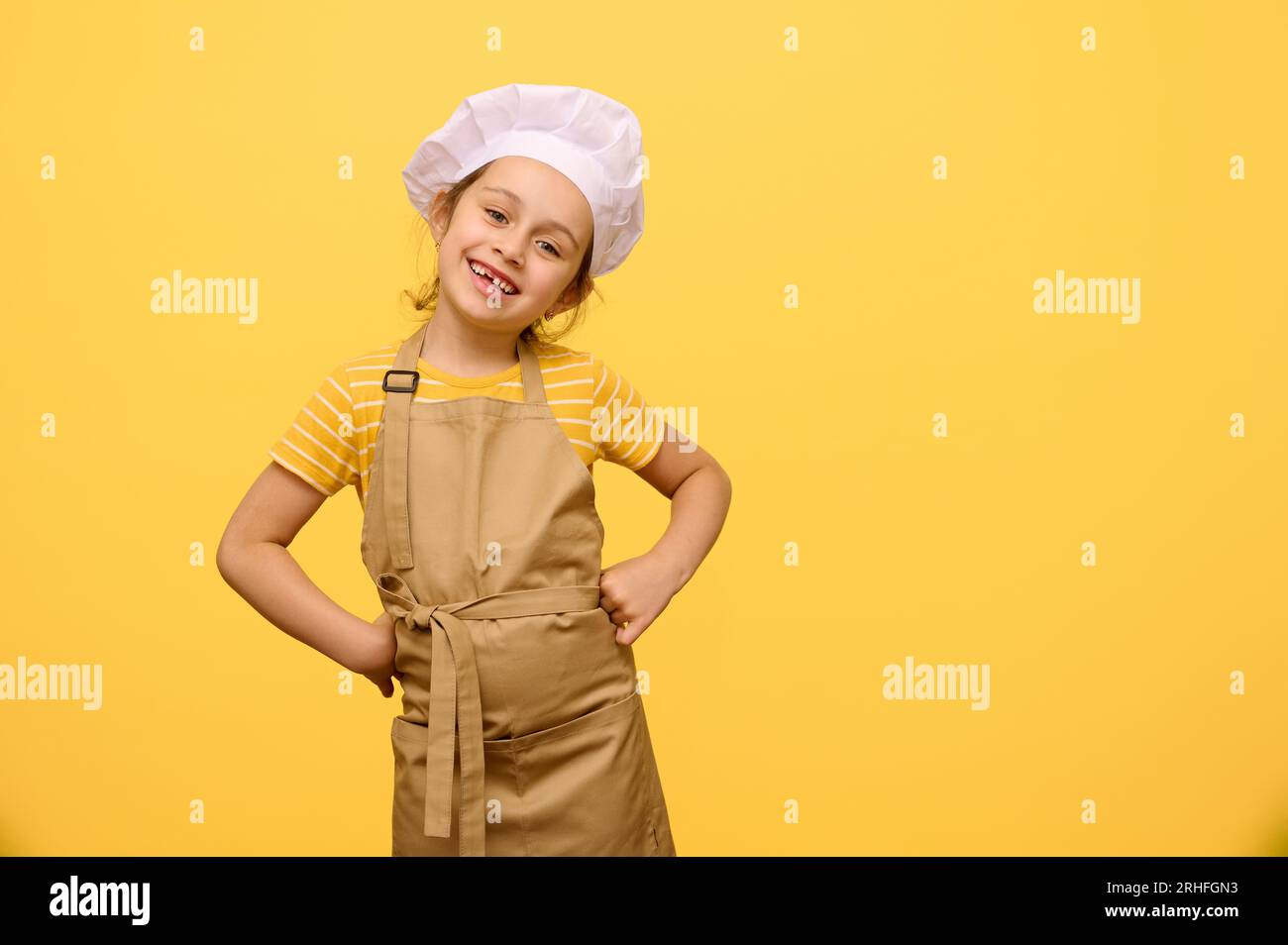 Cute child girl, little chef confectioner baker in apron and white chef ...