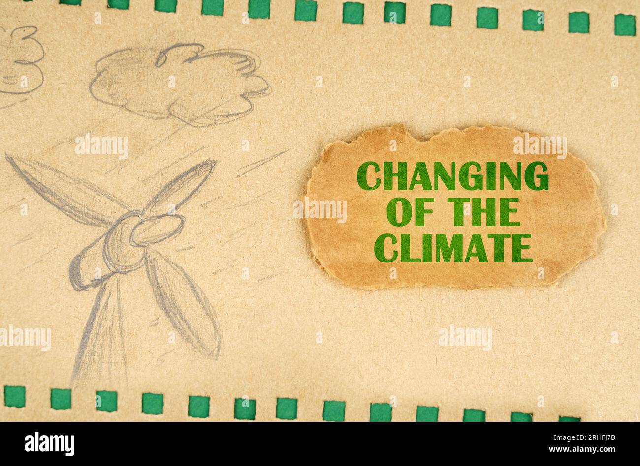 A wind generator and clouds are drawn on cardboard with green holes ...