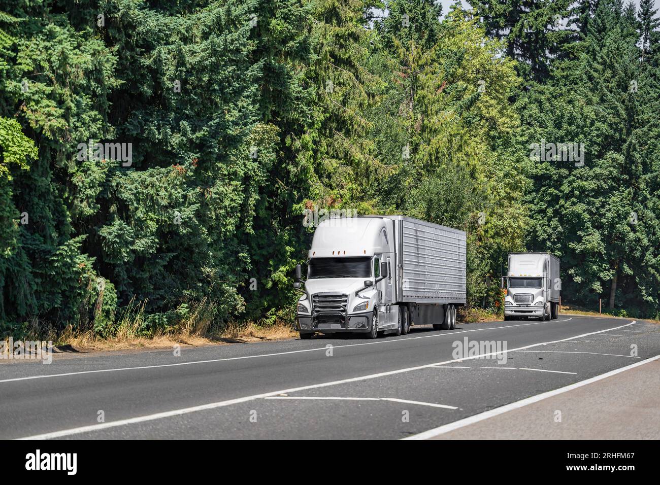 Long haul big rig semi trucks with refrigerator semi trailers standing ...