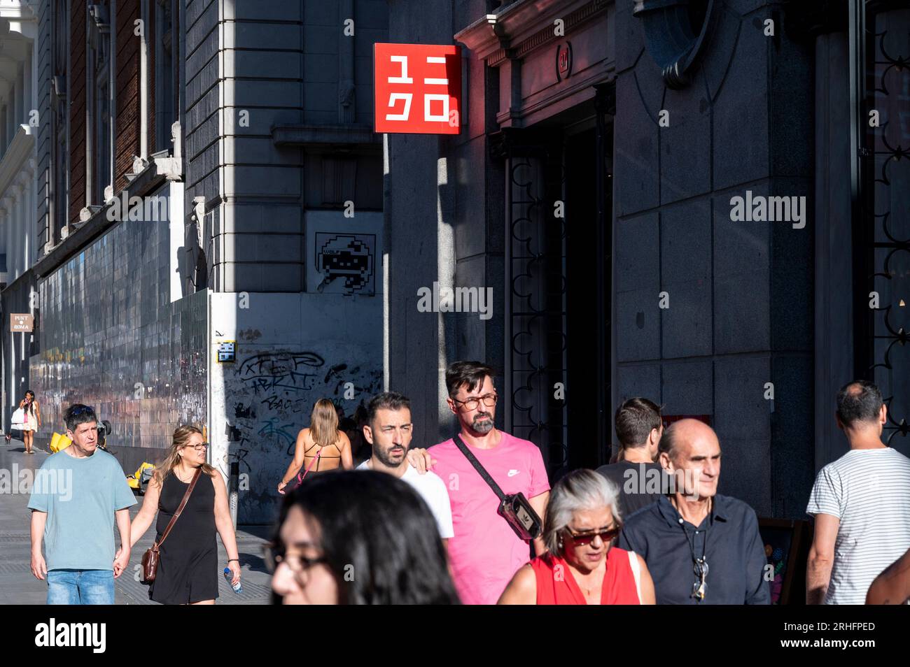 Shoppers and pedestrians walk past the Japanese clothing brand store ...