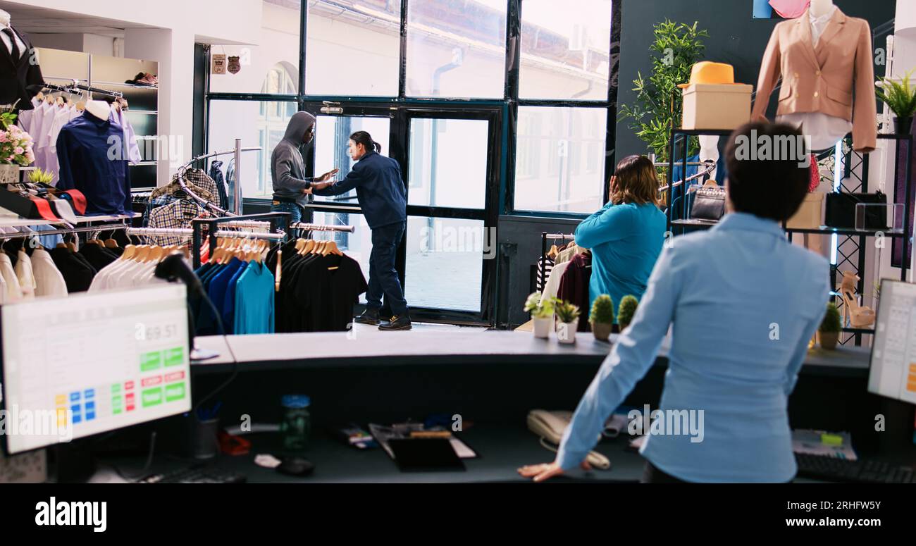 African american robber shoplifting stylish clothes, running from ...