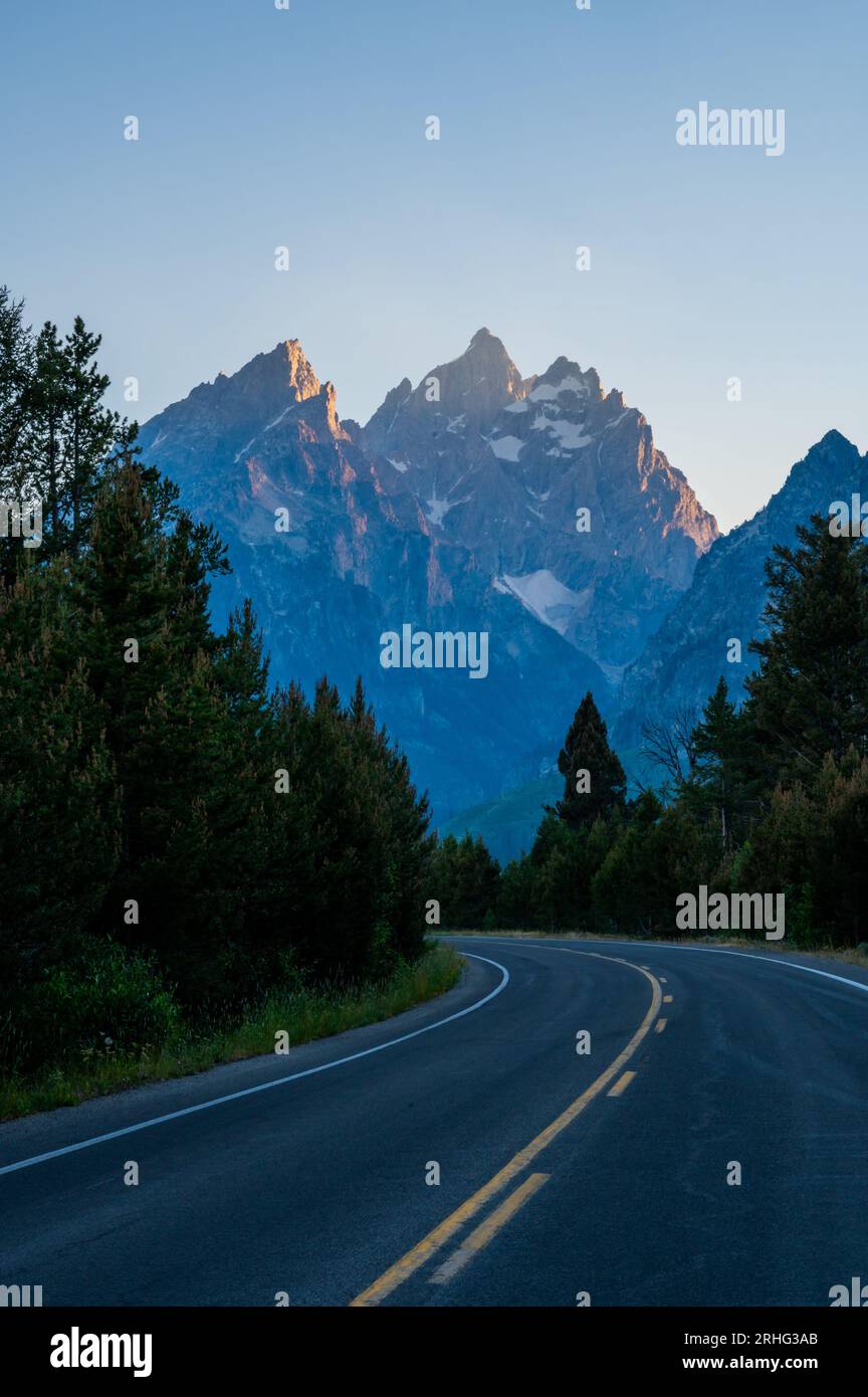 Road Curves Left With Grand Teton In The Distance early in the morning ...