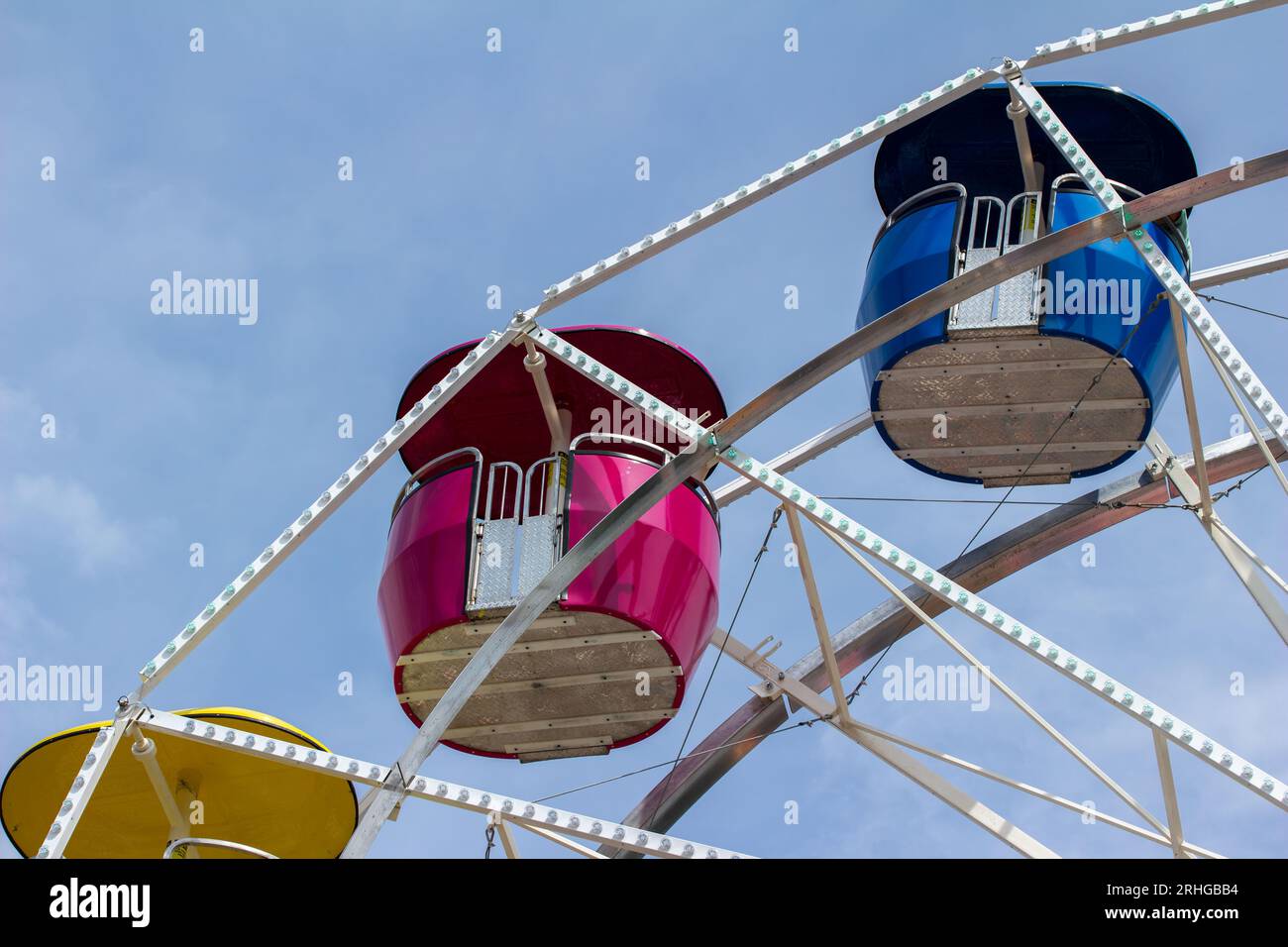 Close upward view of colorful passenger cabins on an amusement park ...