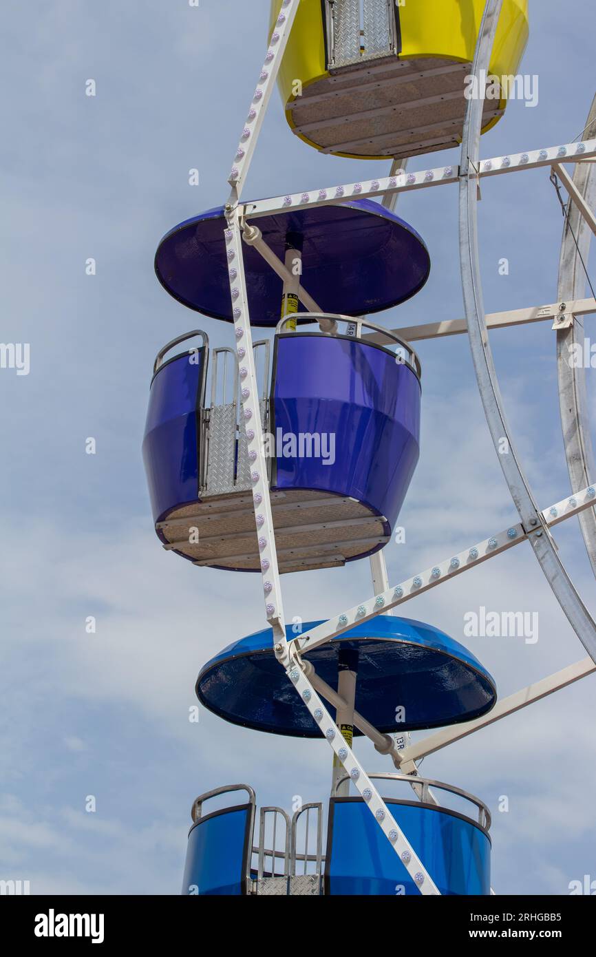 Close upward view of colorful passenger cabins on an amusement park ...