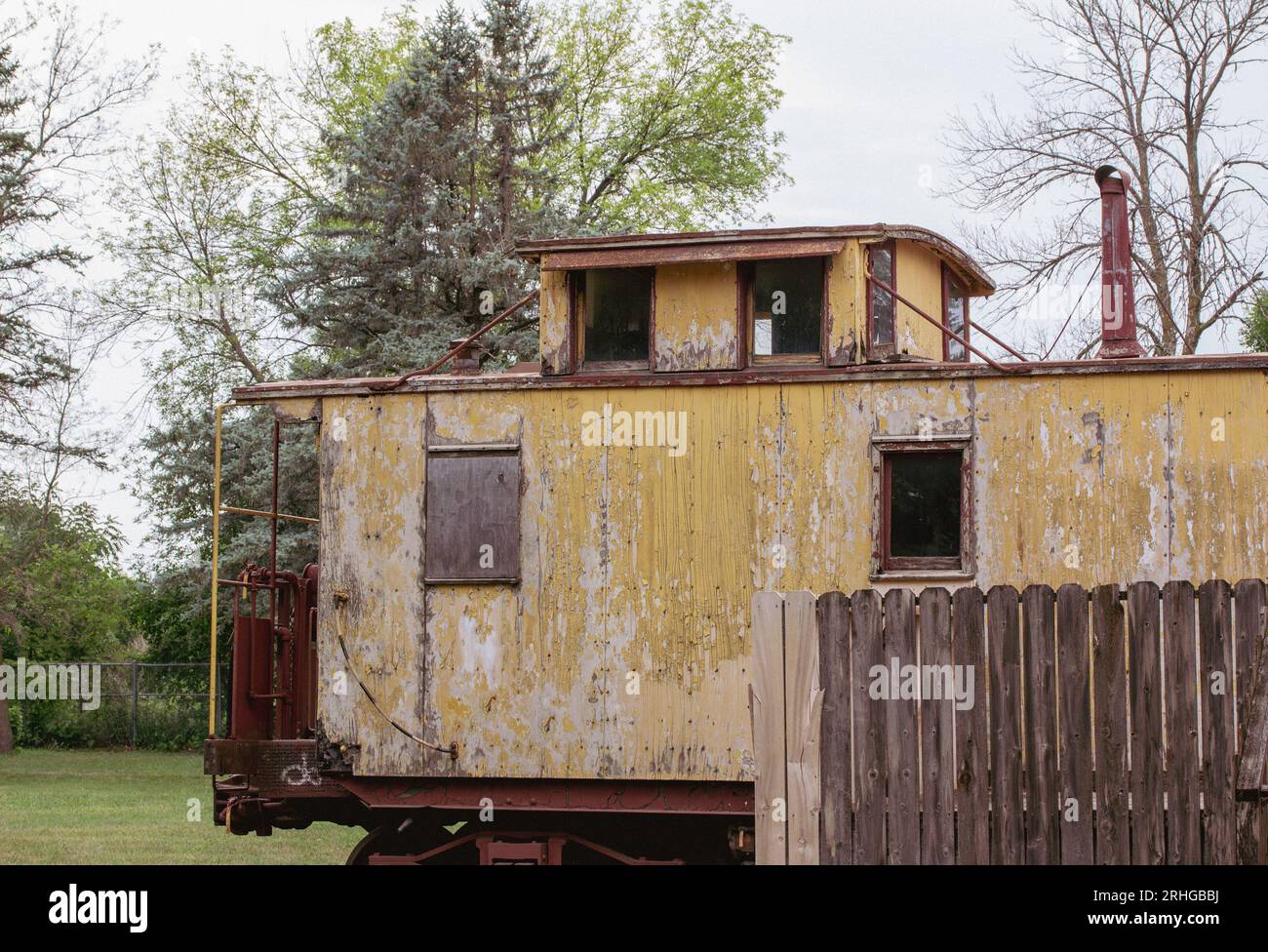 Exterior view of a deteriorating yellow 19th century railway train ...