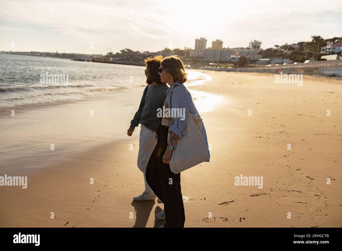 Happy romantic couple in love is walk holding hands across the beach on ...
