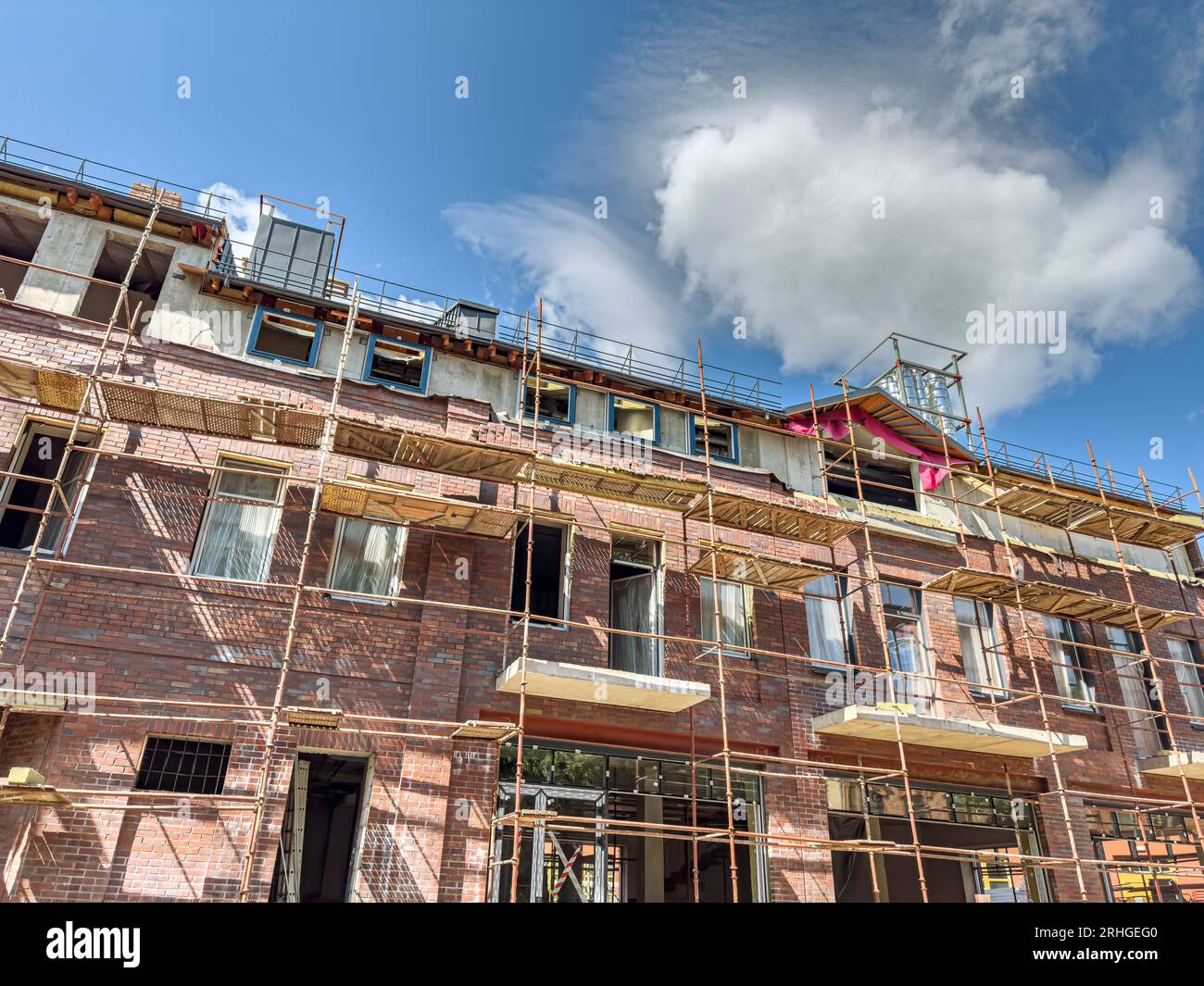 brick building under renovation surrounded by scaffolding. facade ...