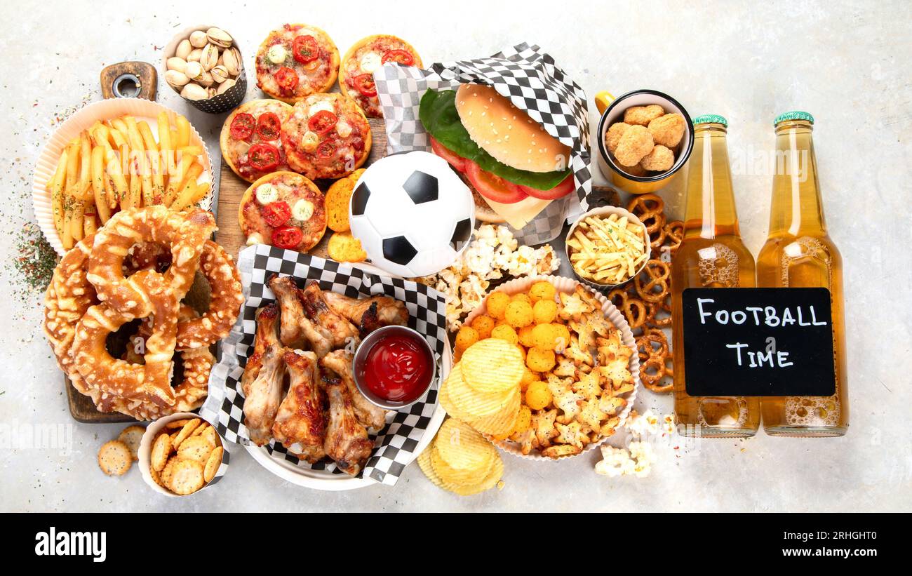 Table scene with large variety of take out and fast foods. Hamburger ...