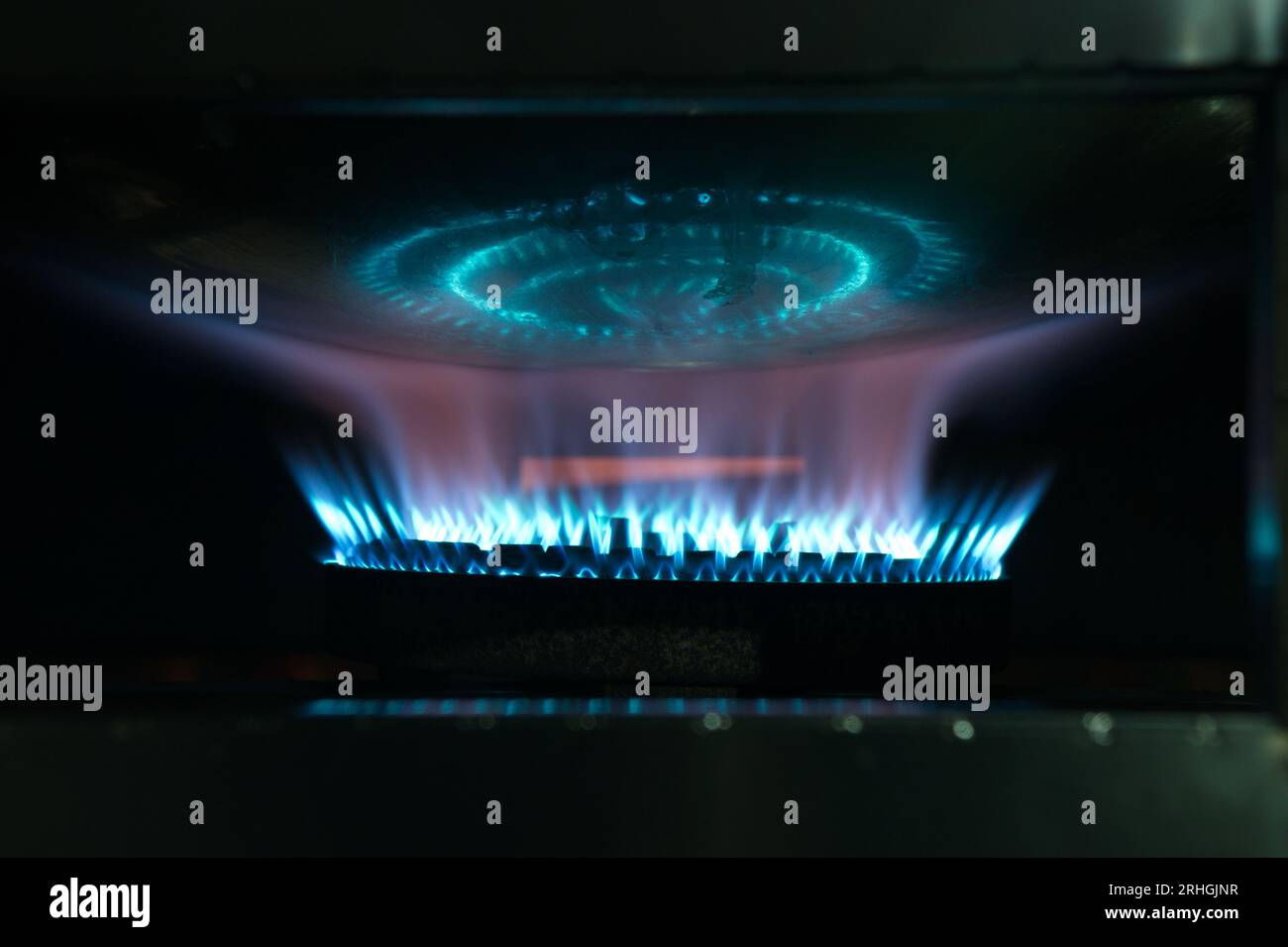 Natural gas blue fire flame on kitchen burner gas stove on dark ...