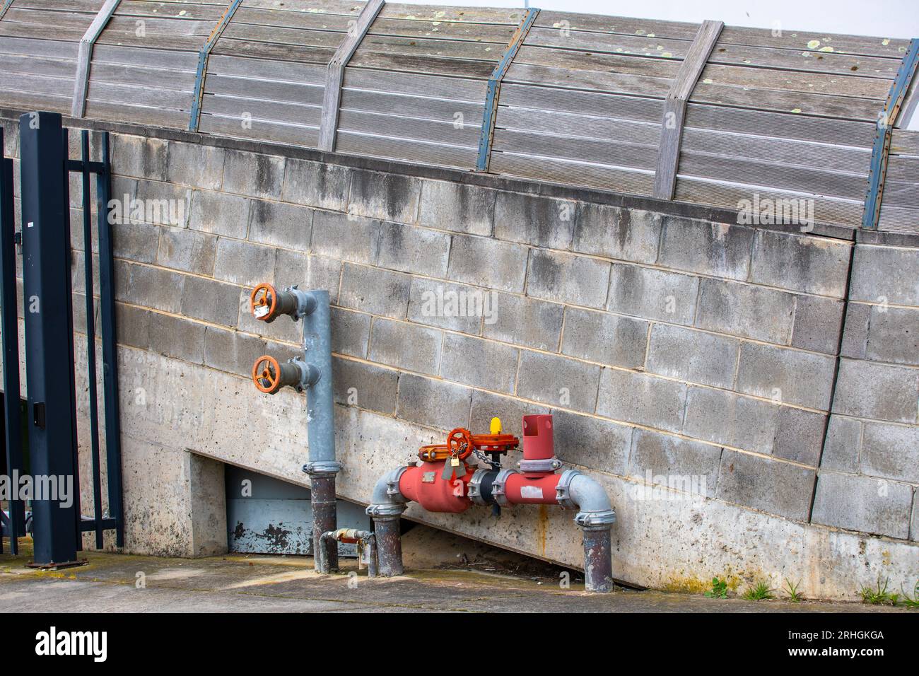 A fire hydrant system against a grey concrete brick ramp in Melbourne ...