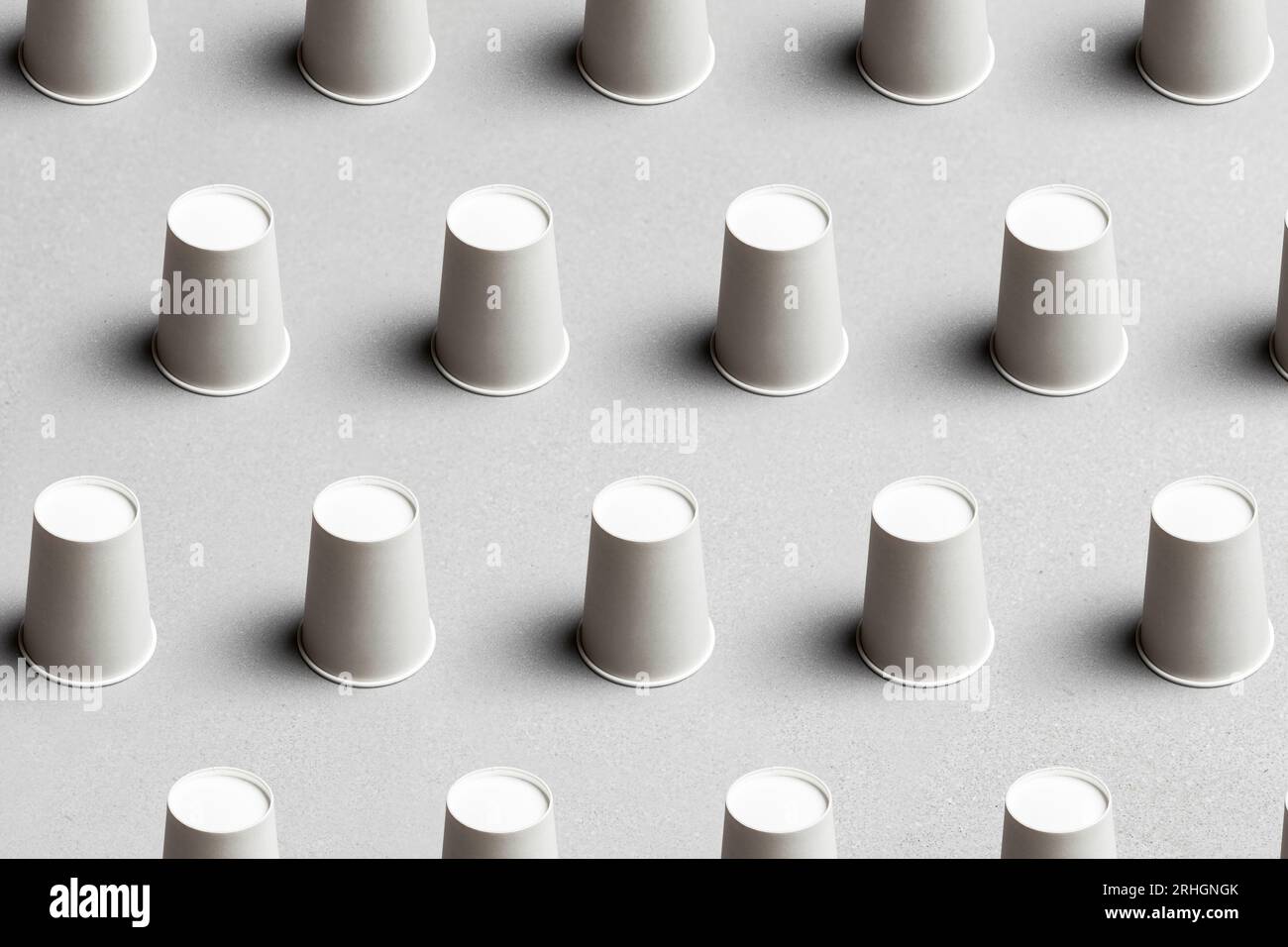 Takeaway coffee cups perfectly aligned in a pattern on a white surface ...