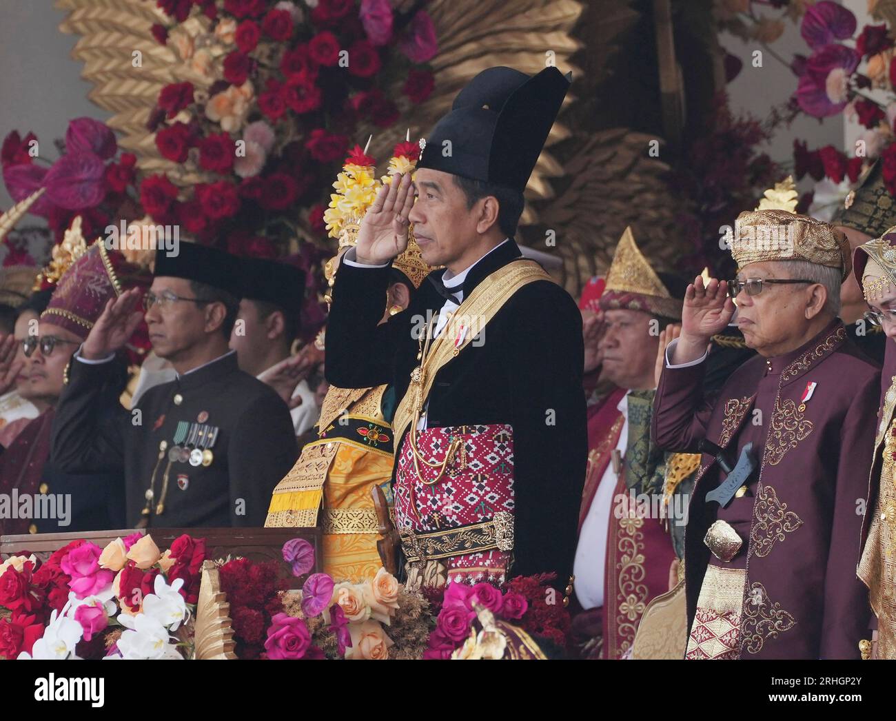 Indonesian President Joko Widodo, center, in traditional dress, salutes ...
