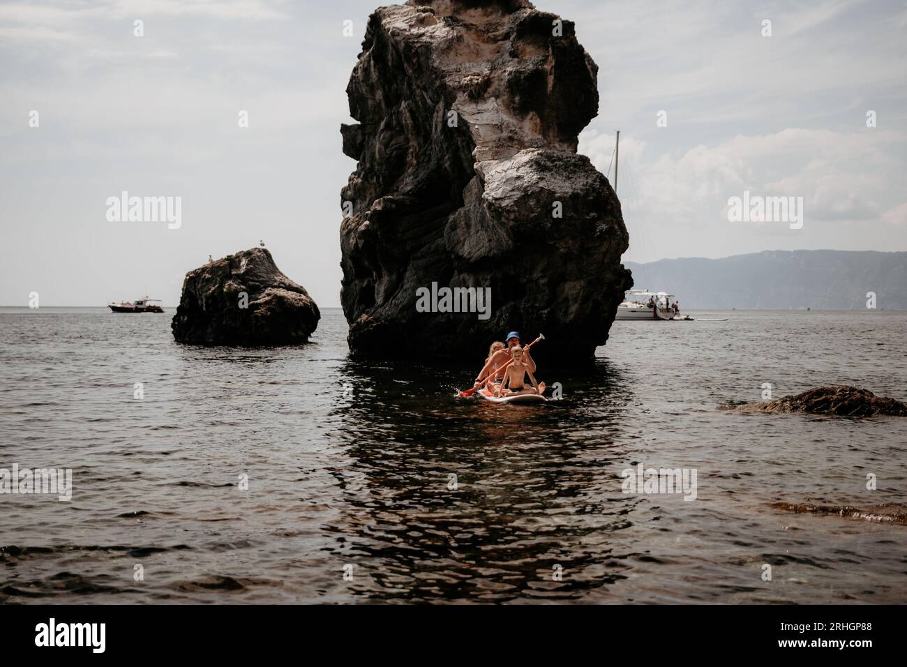 Family sea sup. Young happy father with his son and daughter Floating ...