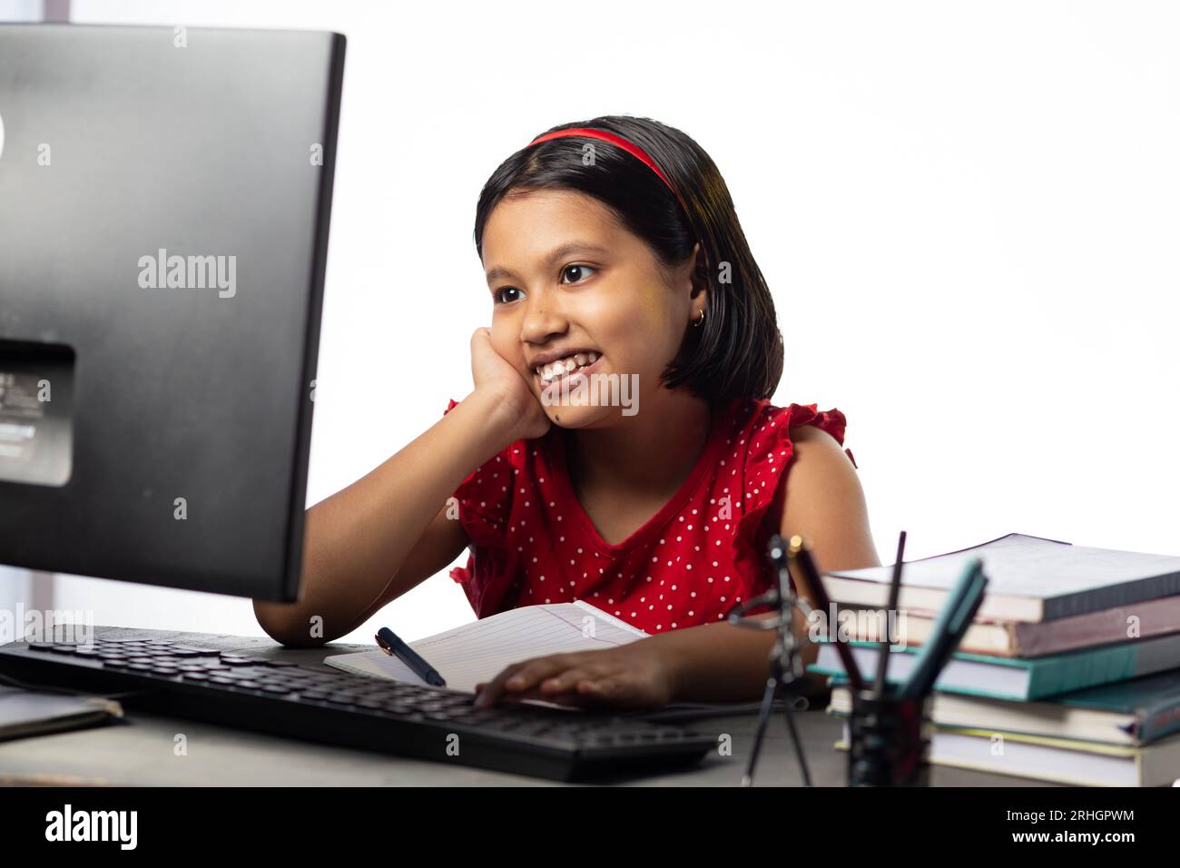 A pretty beautiful Indian girl child studying with desktop computer at ...