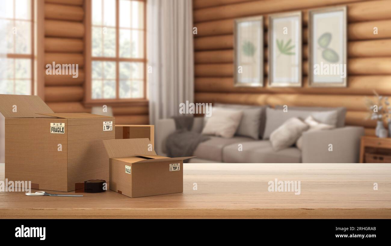 Wooden table, desk or shelf with stack of cardboard boxes over blurred ...