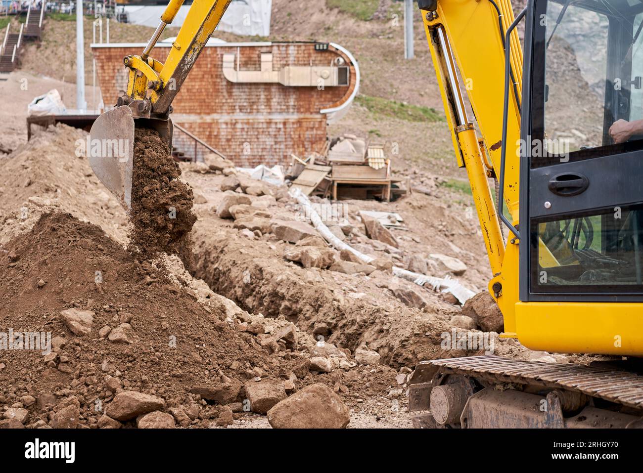 Excavator works in the highlands. Makes a trench for communications ...