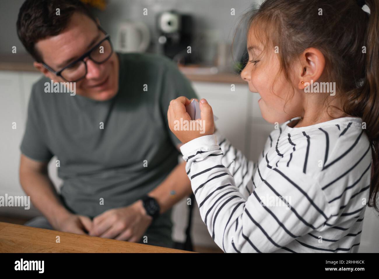 Father and child girl doing origami crafts together. Modern parenthood ...