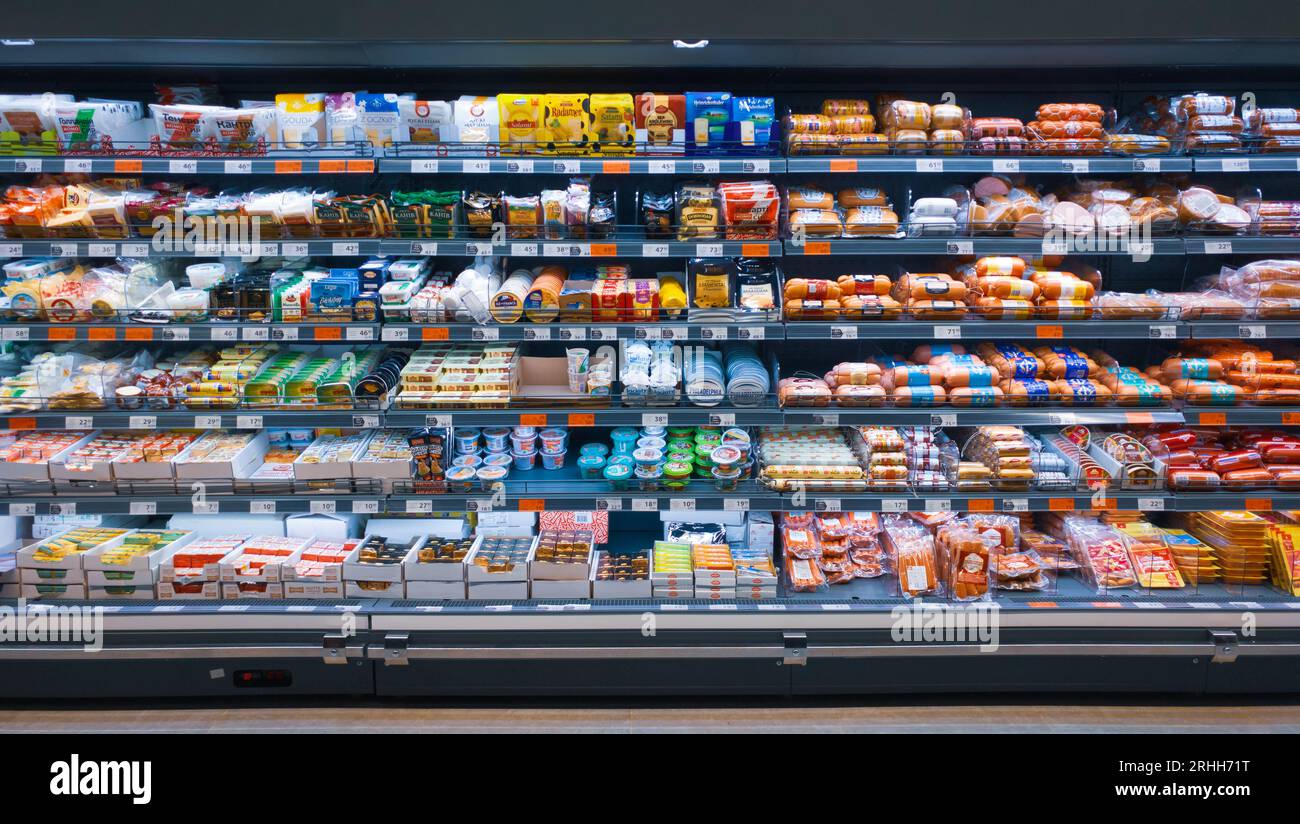 Food market refrigerator display shelves with dairy and meat goods ...