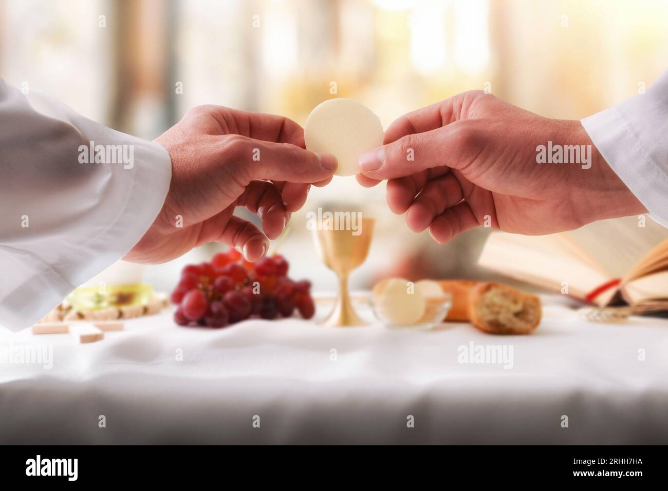 Hands of a priest consecrating a host as the body of Christ to ...