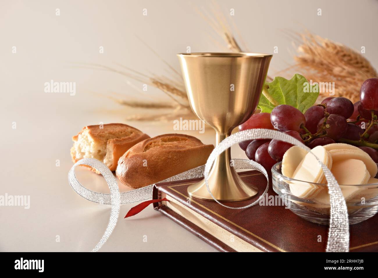 Cup of wine and hosts on bible for eucharist with bread and decoration ...