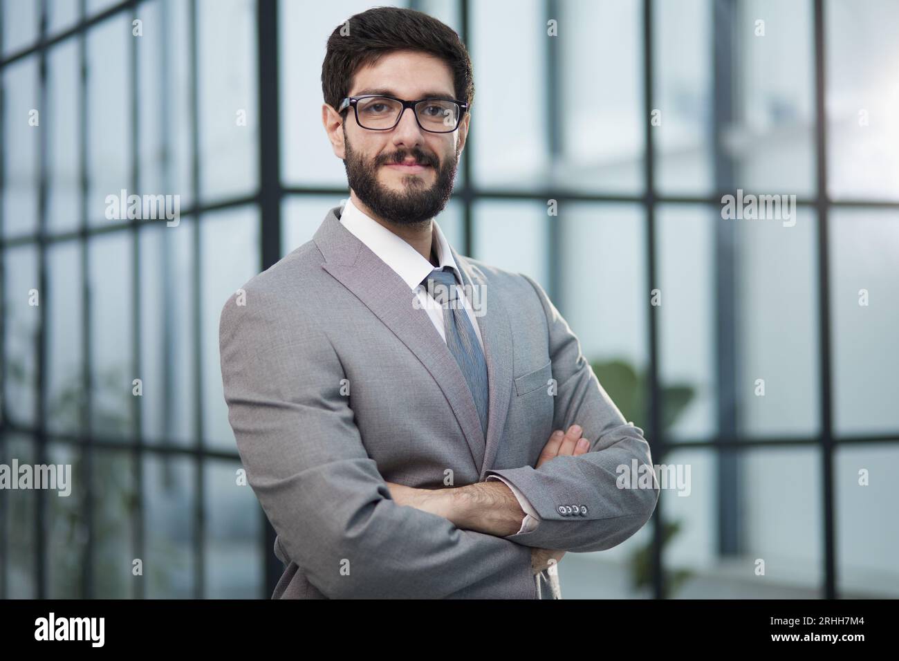 Portrait of serious handsome successful businessman in glasses and suit ...