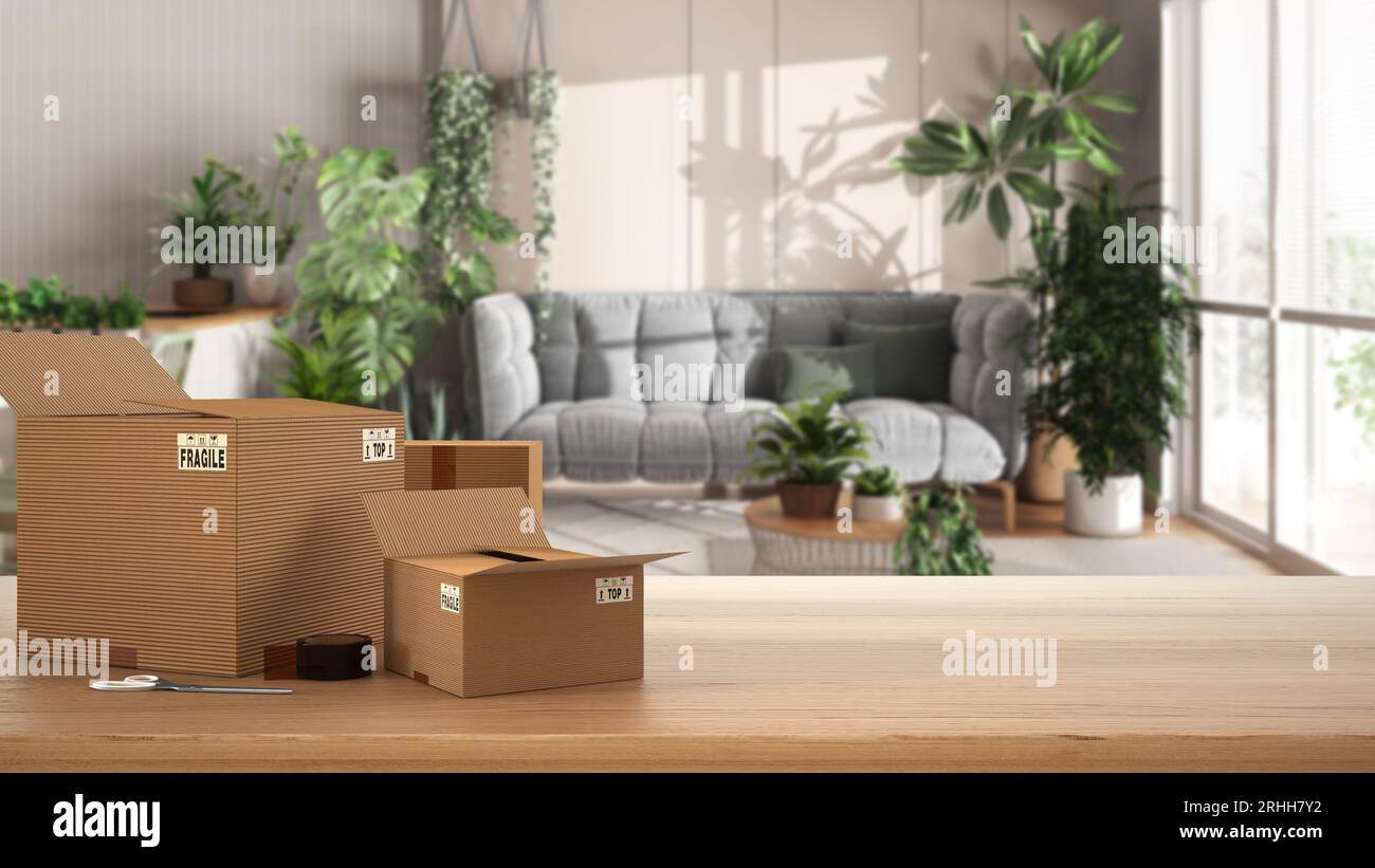 Wooden table, desk or shelf with stack of cardboard boxes over blurred ...