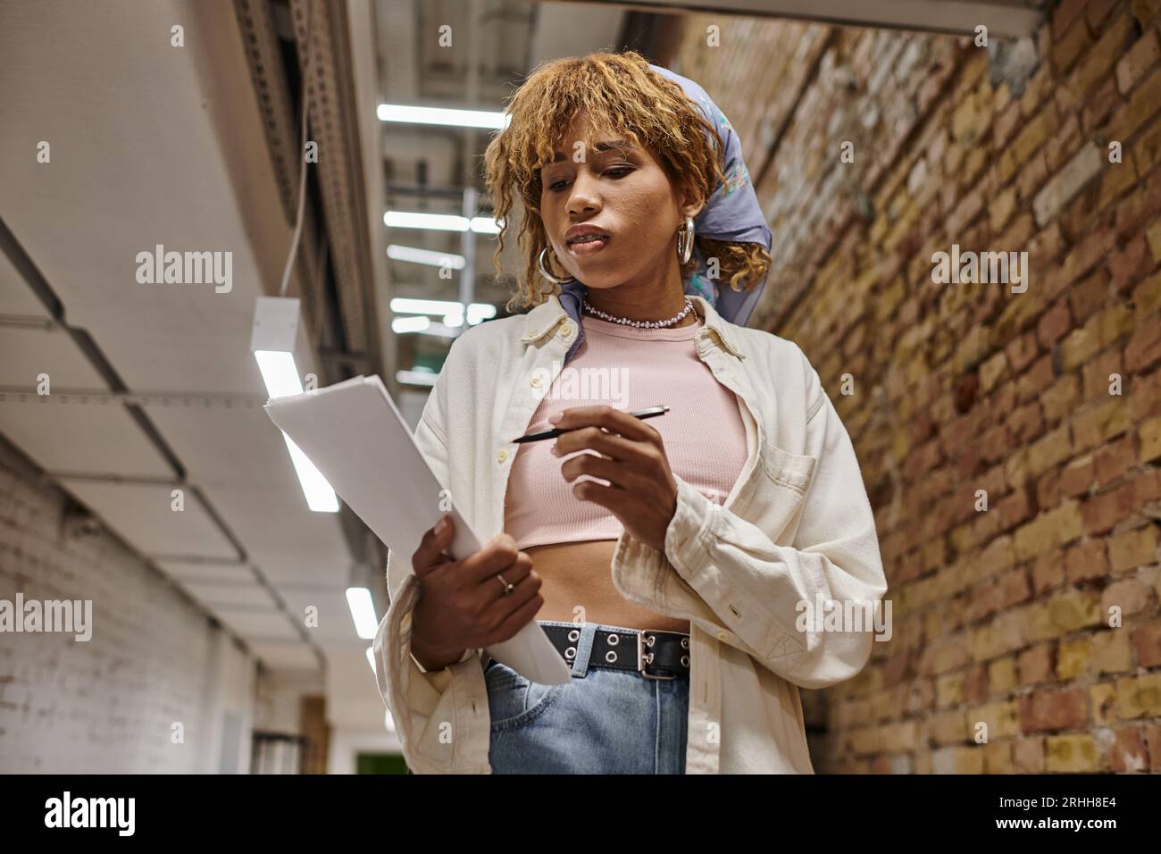 young african american manager with braces holding papers, startup ...