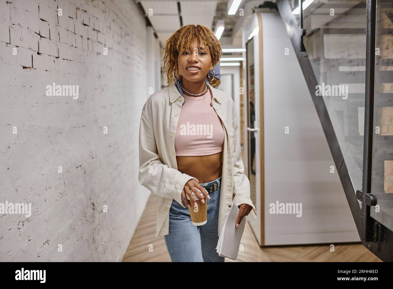 happy african american woman with braces holding papers and coffee to ...
