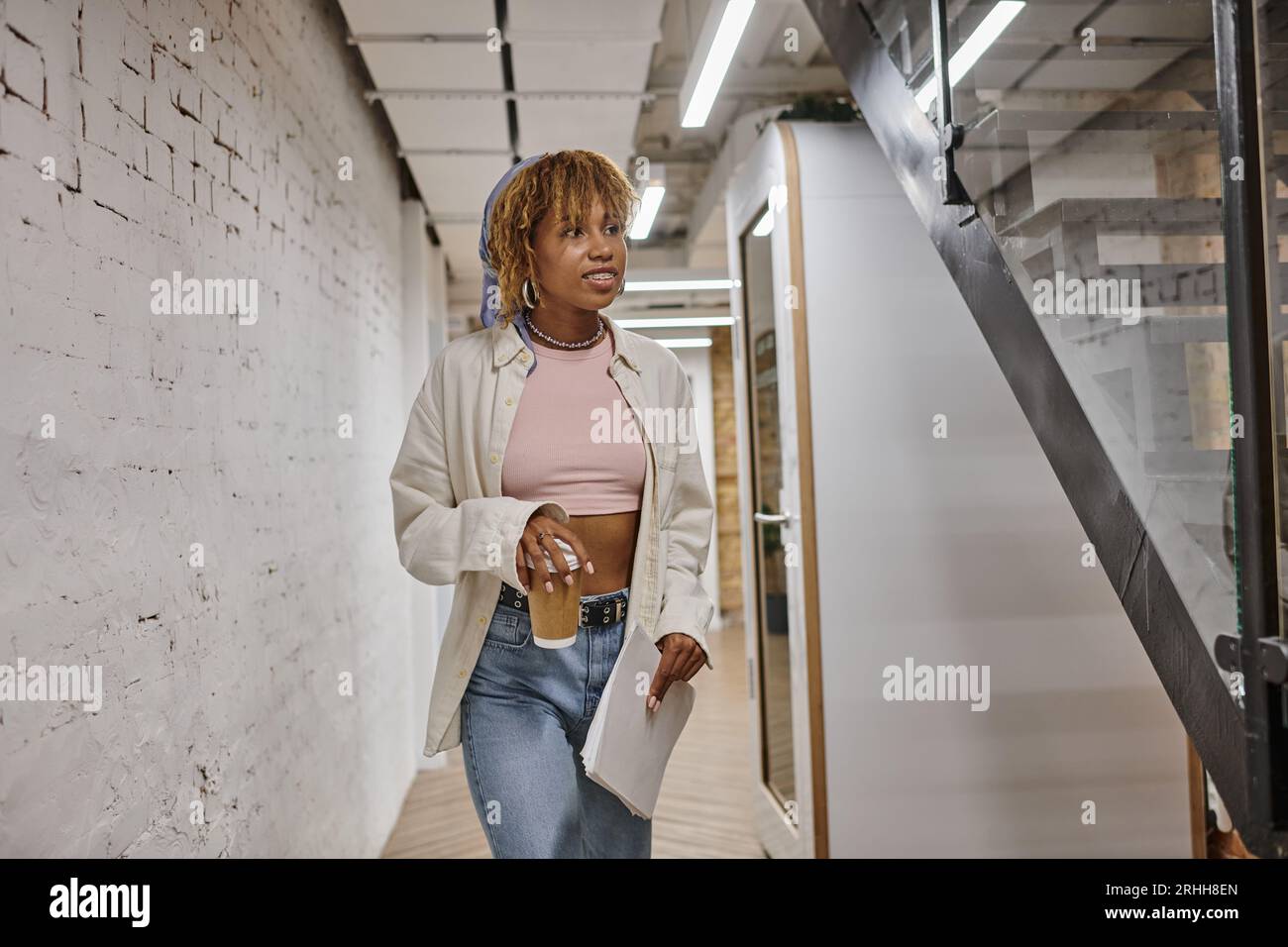 young african american woman with braces holding papers and coffee to ...