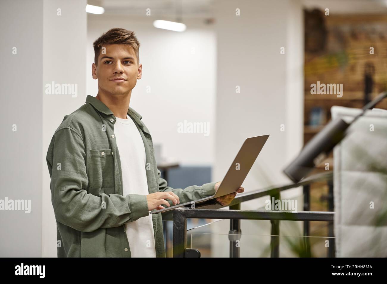 young businessman using laptop, coworking, modern office, generation z ...