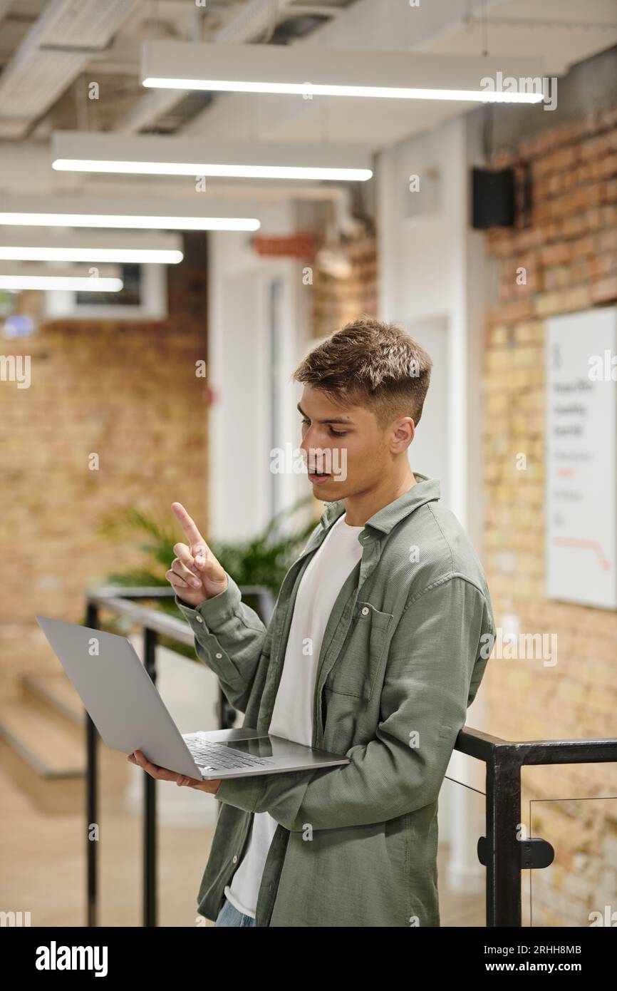 young man using laptop, video call, idea sign, modern coworking, office ...