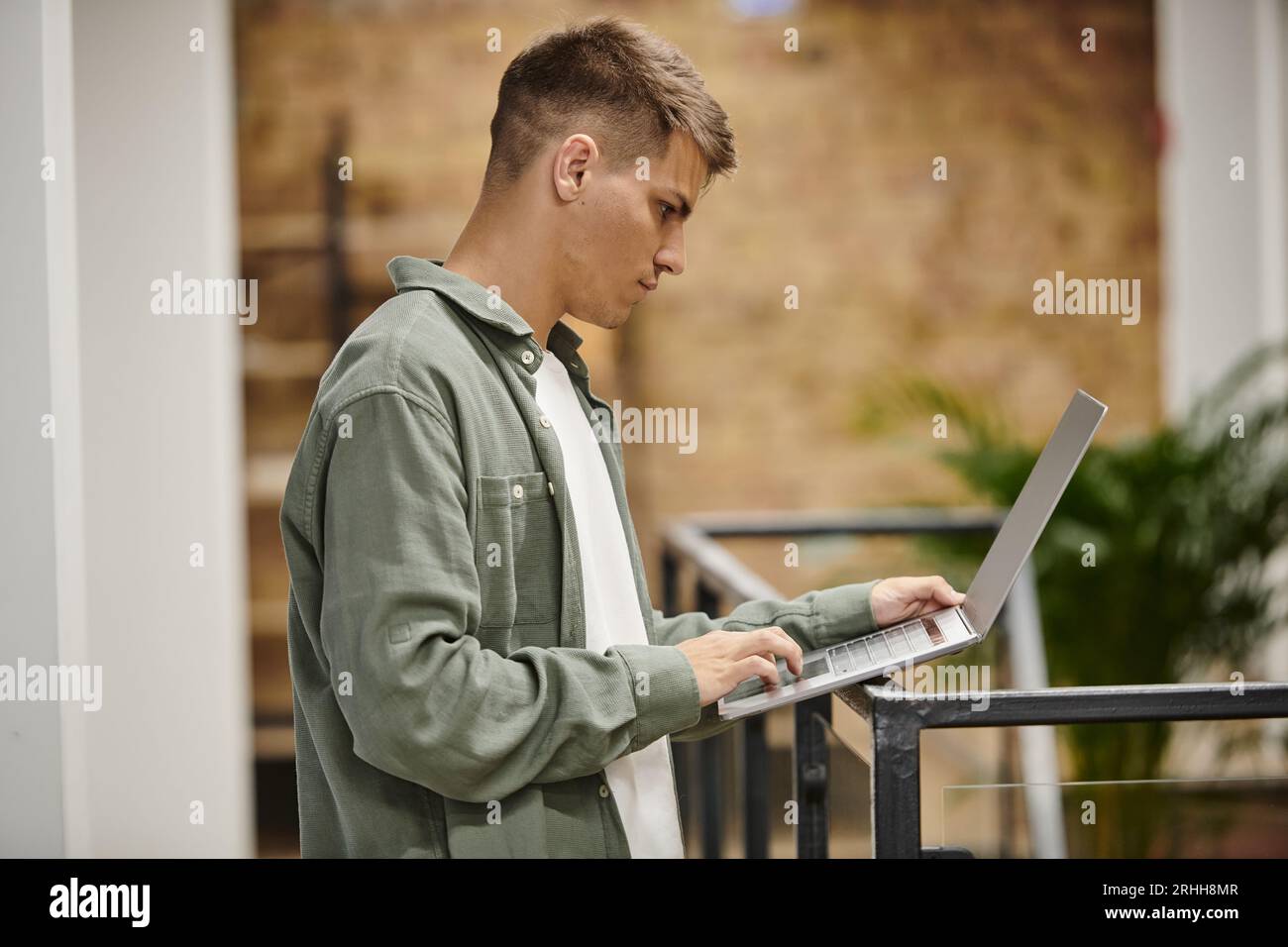 side view, man using laptop, modern coworking, office environment ...