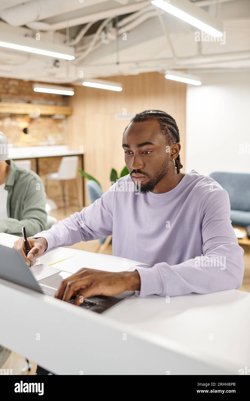coworking, african american man taking notes, and using laptop, startup ...
