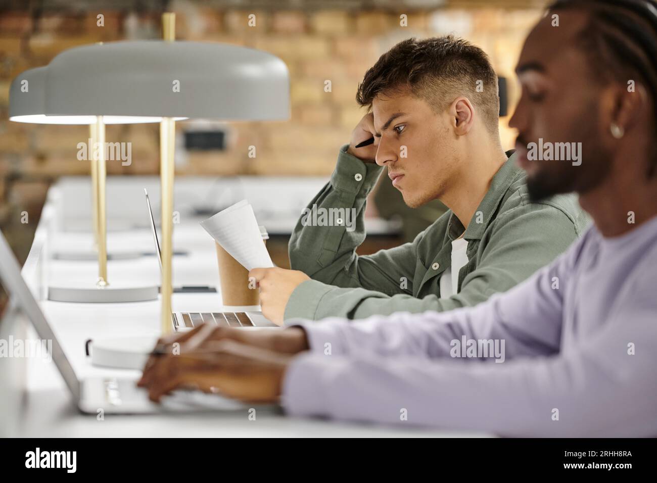 pensive man checking documents, working in office, diverse colleagues ...